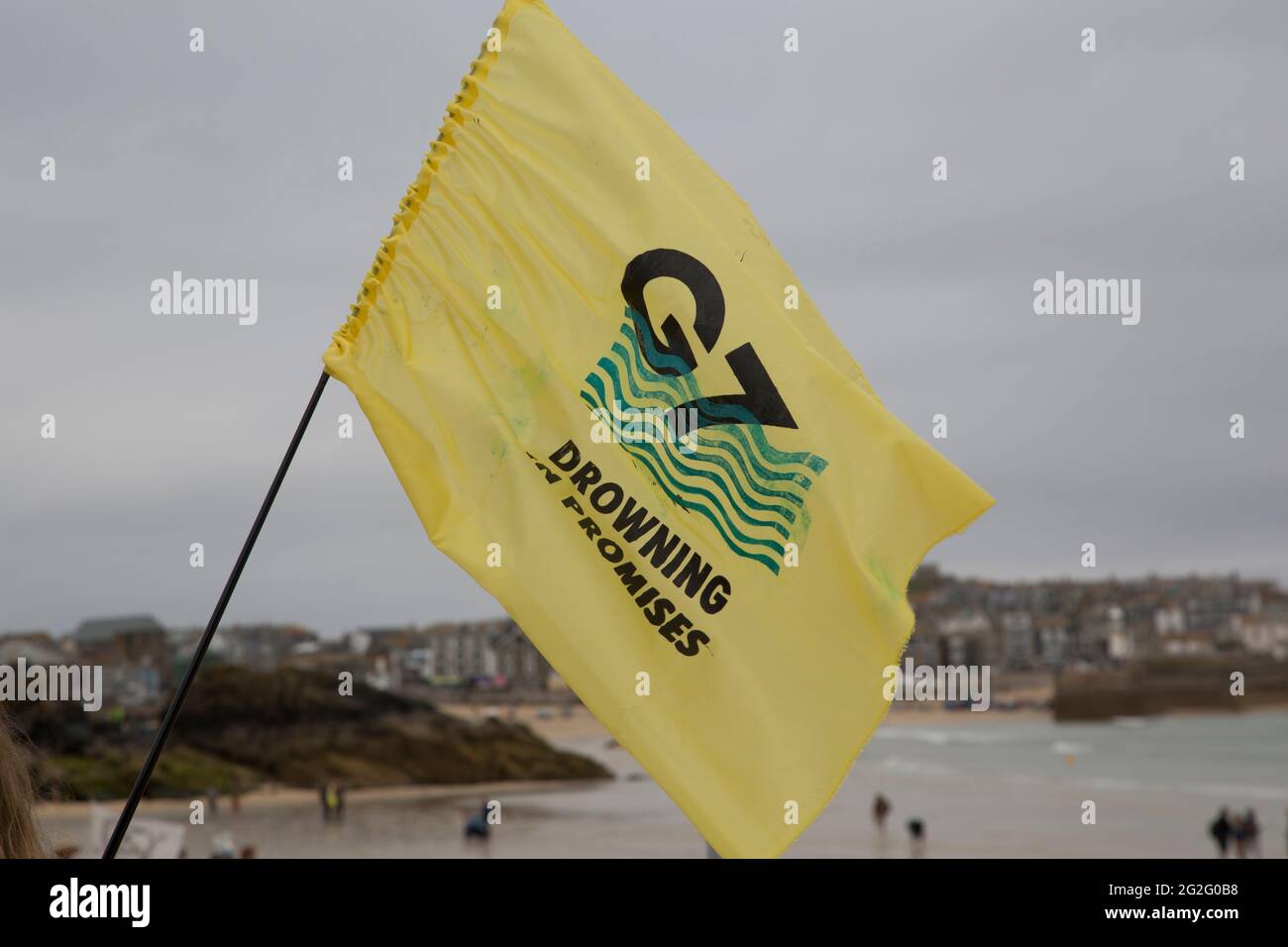 St Ives, UK. 11th June, 2021. Climate protesters fly flags on ...