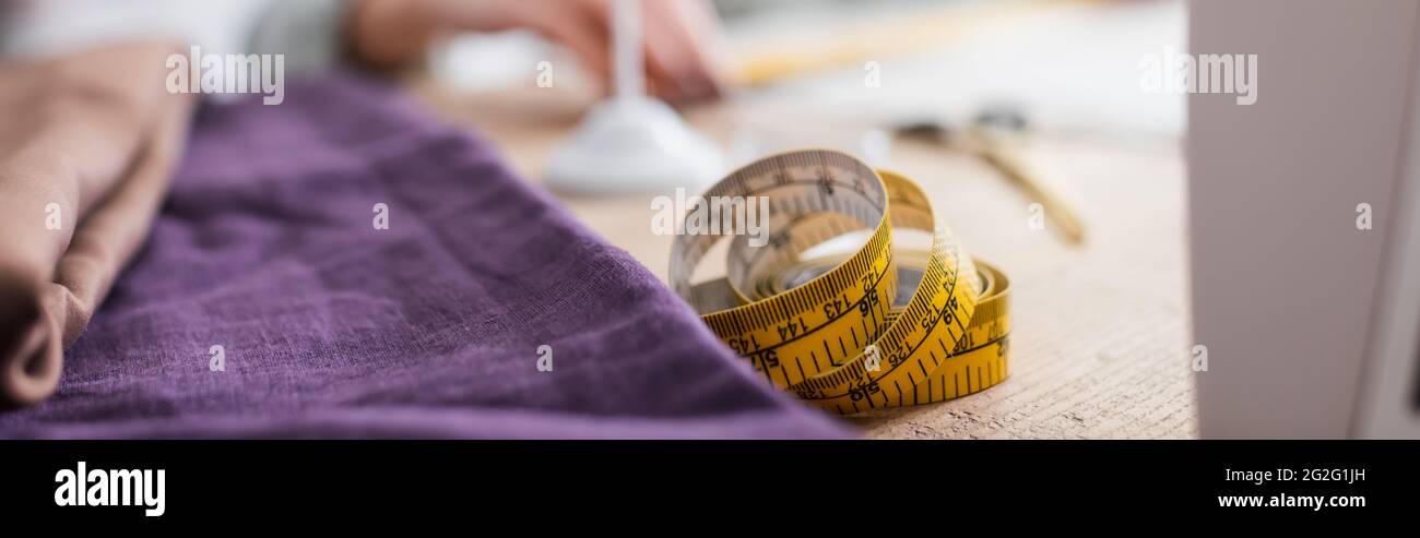 Measuring tape and cloth on table, banner Stock Photo - Alamy