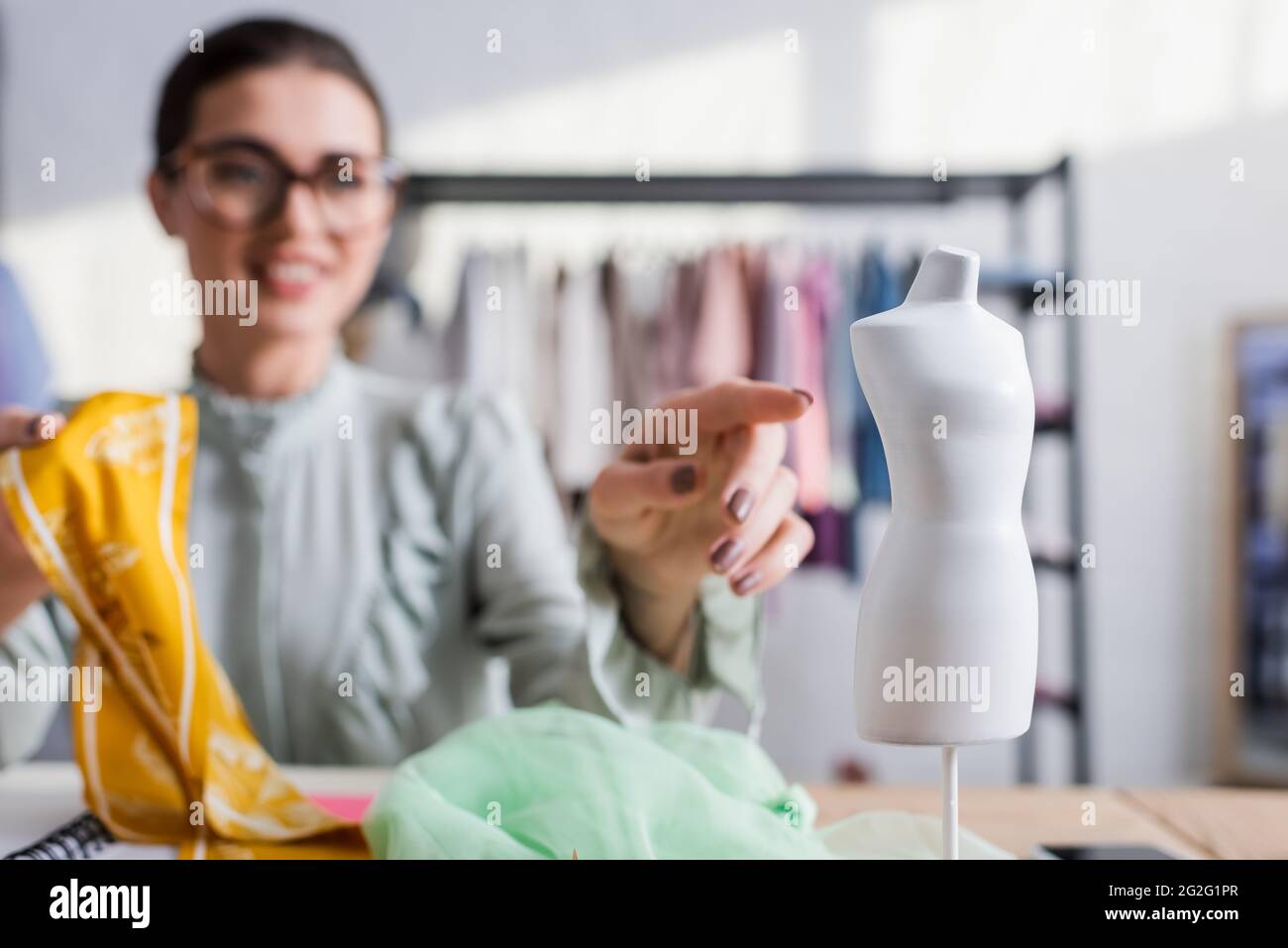 Mannequin near blurred designer with cloth pointing with finger Stock ...