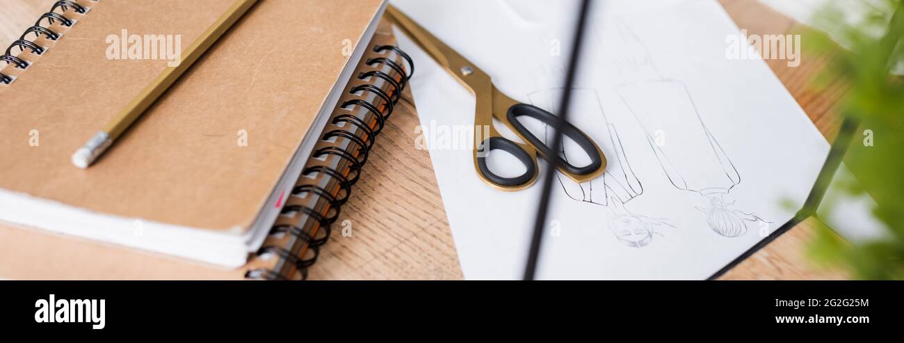 Scissors near sketches and notebooks on table, banner Stock Photo - Alamy
