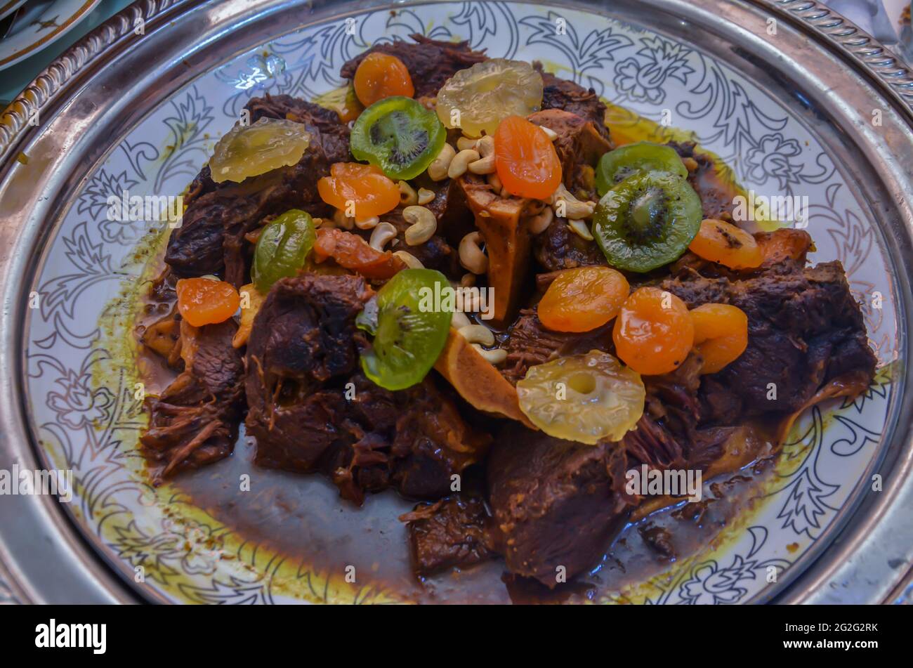 A plate of Moroccan meat decorated with apricots, pineapple and kiwi ...