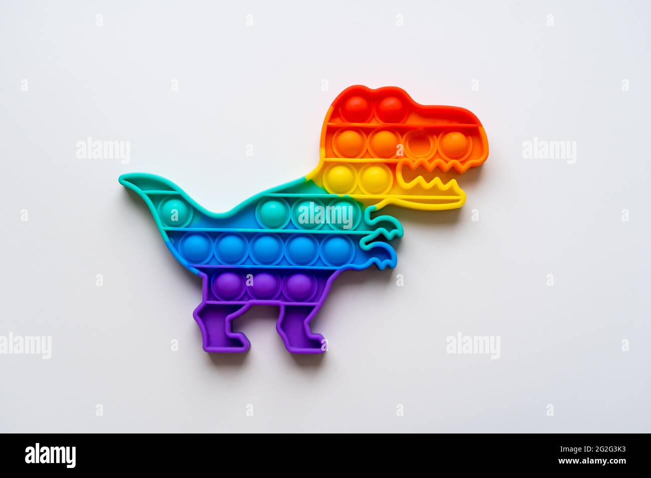 Popit rainbow toy in rainbow colours and dino shape. Trendy bubble pop ...