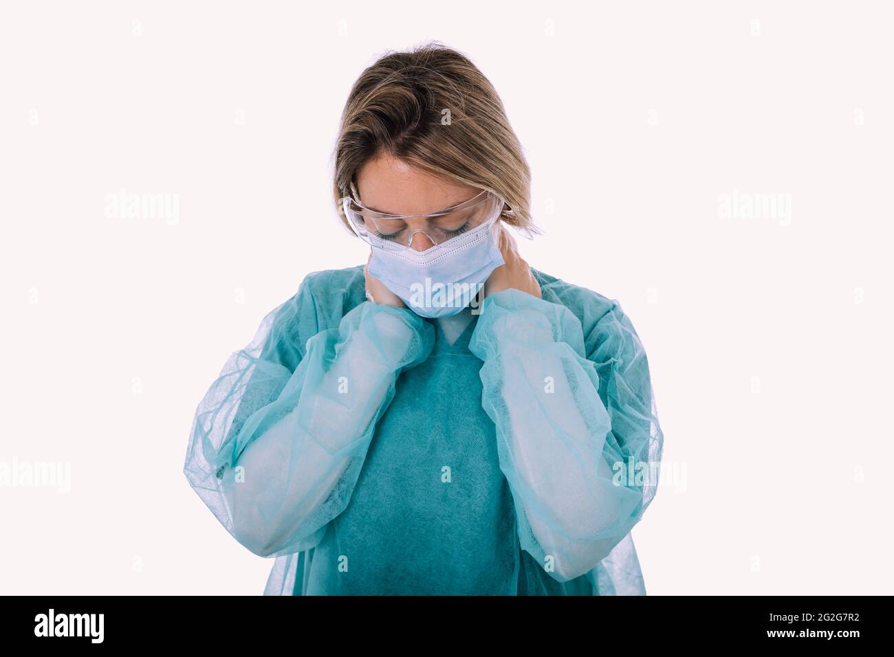 Sad and overwhelmed female doctor or nurse wearing protective face mask ...