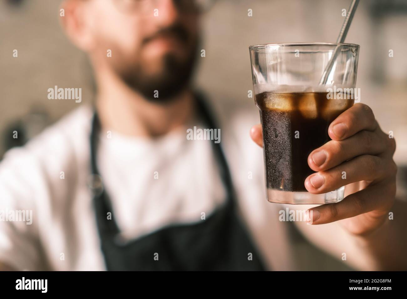 Barista holds a glass of cold brew coffee with ice Stock Photo - Alamy