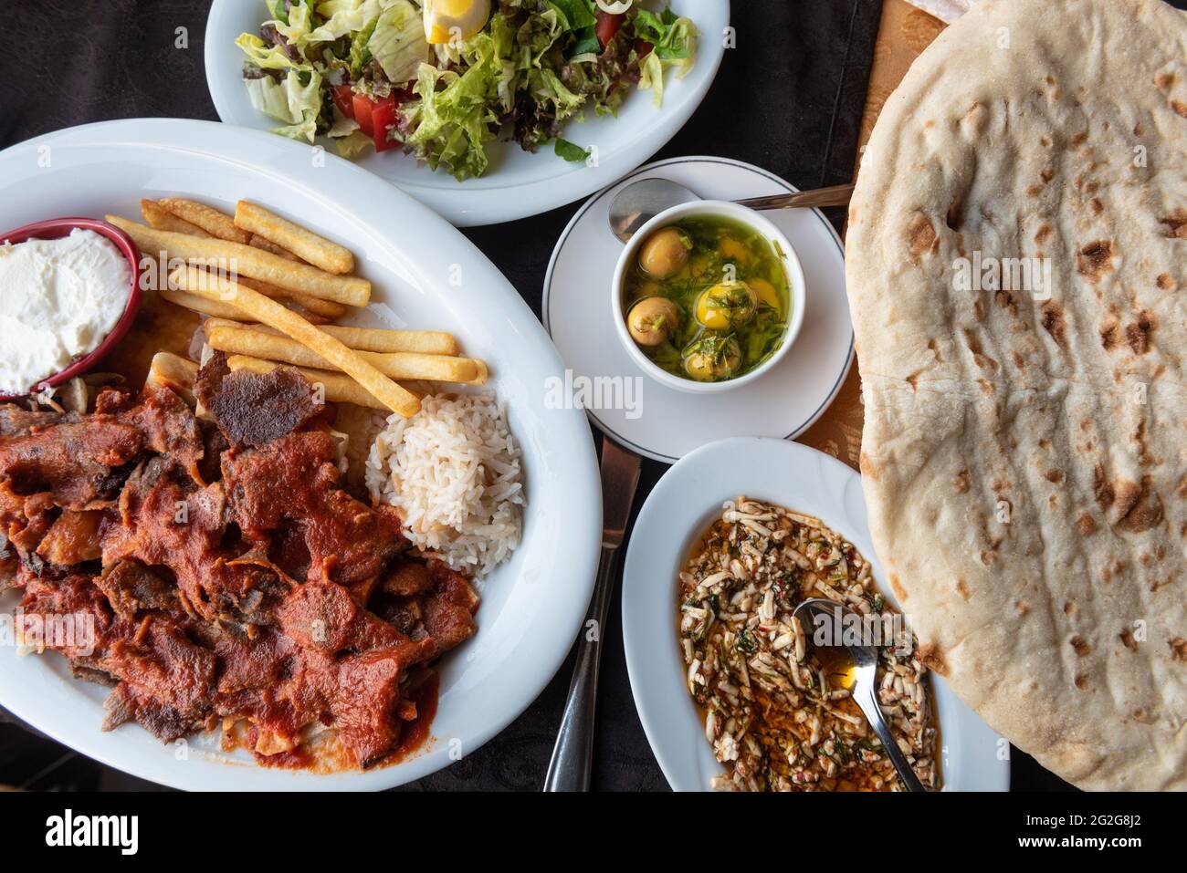 Plate of or Bursa Kebab with a Turkish mezze and traditional bread a ...
