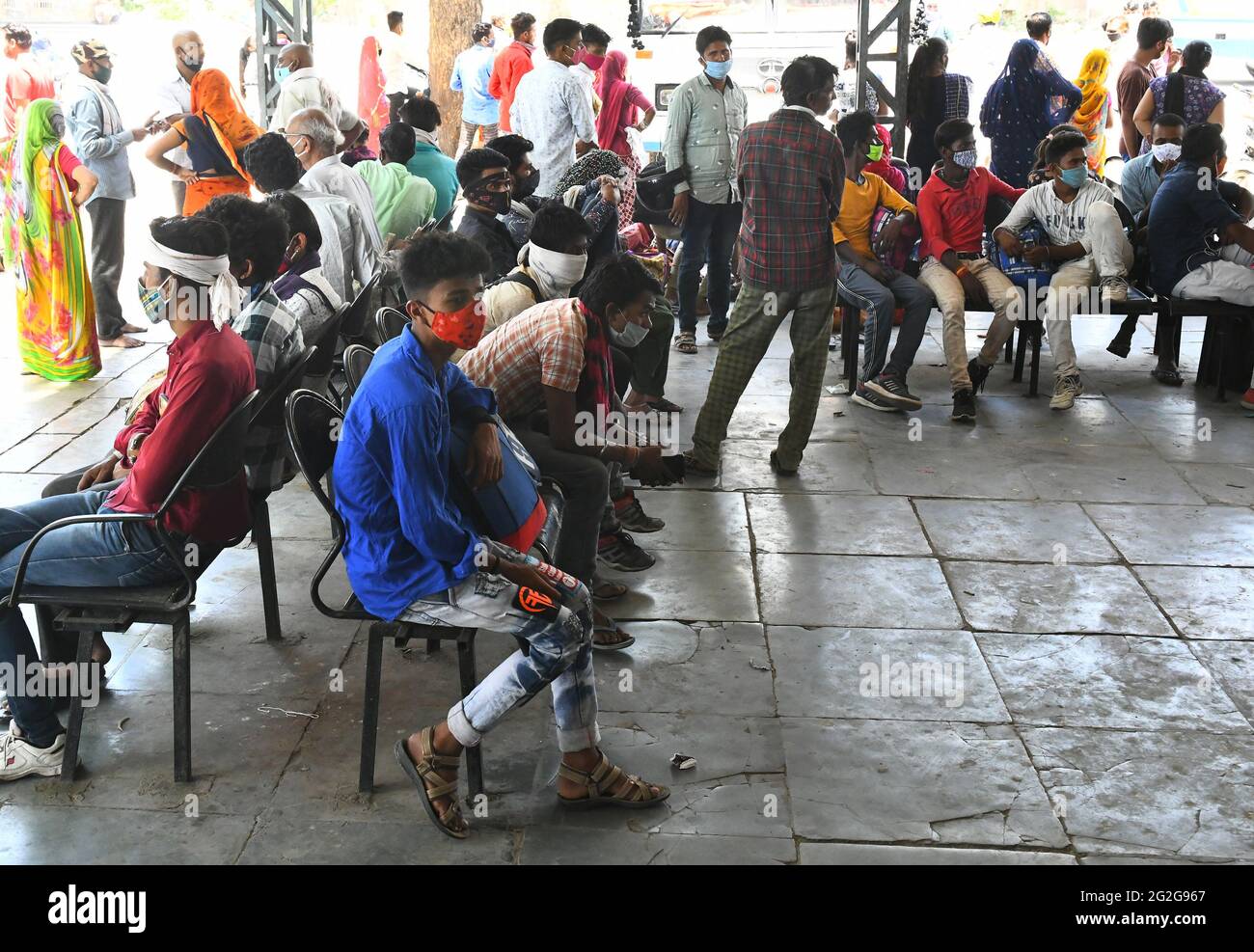 Passengers, not adhering to social distancing norms, wait to board ...