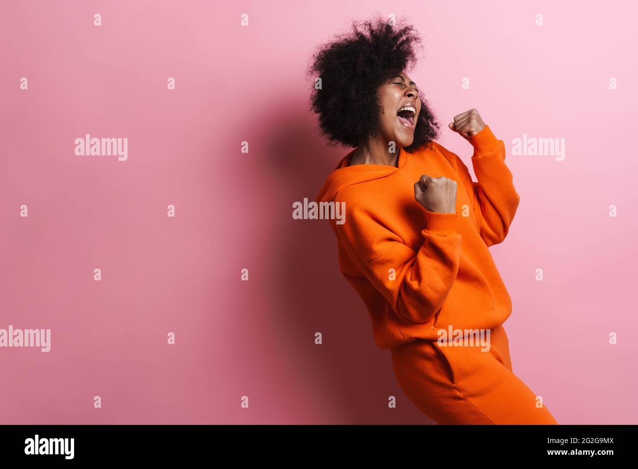 Delighted african american girl screaming and making winner gesture ...