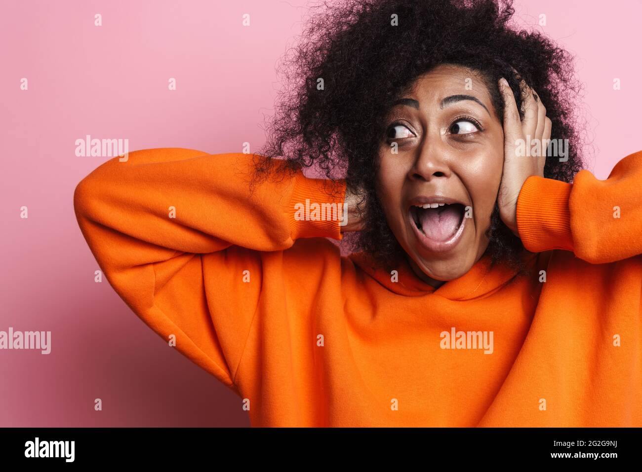 Excited african american woman covering her ears and screaming isolated ...