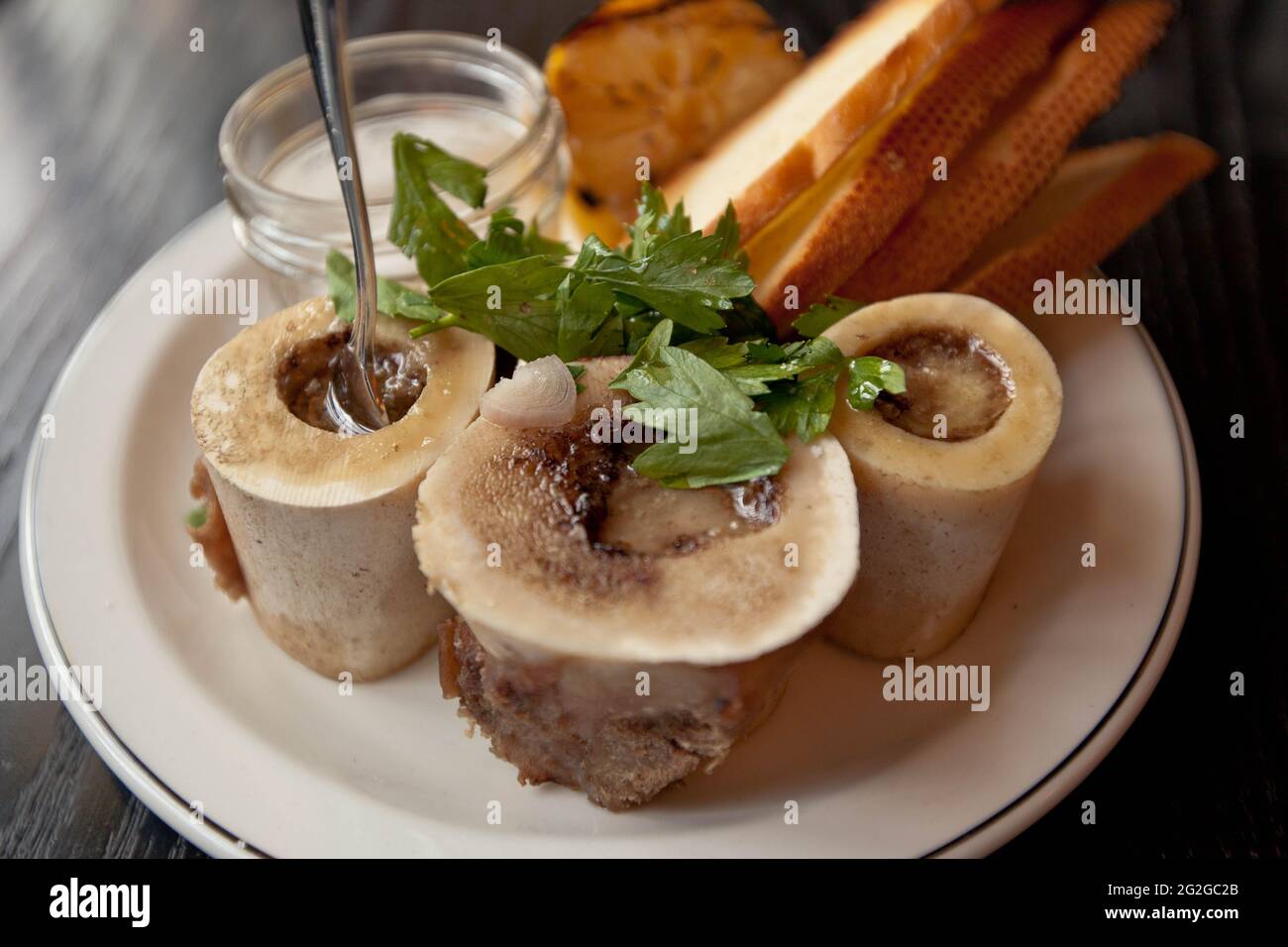 Bone marrow topped with parsley and served with toast Stock Photo - Alamy