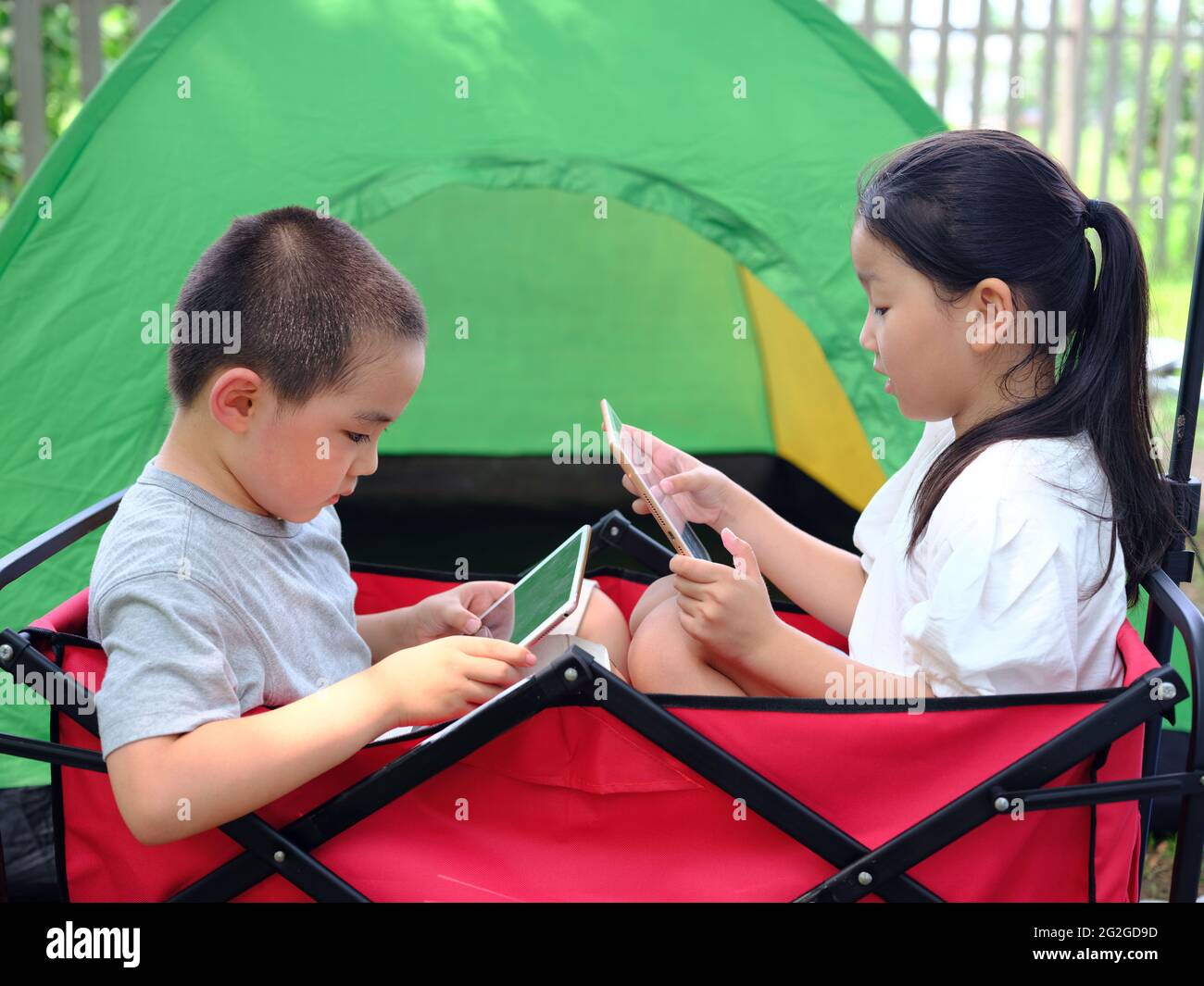 Two kids playing with tablets high quality photo Stock Photo - Alamy
