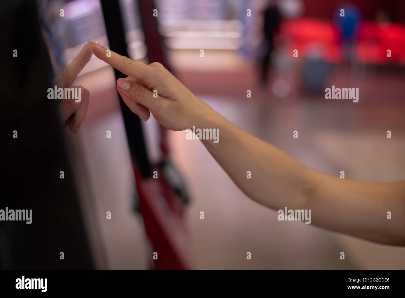 Close-up of female hand on touch screen information counter in shopping ...