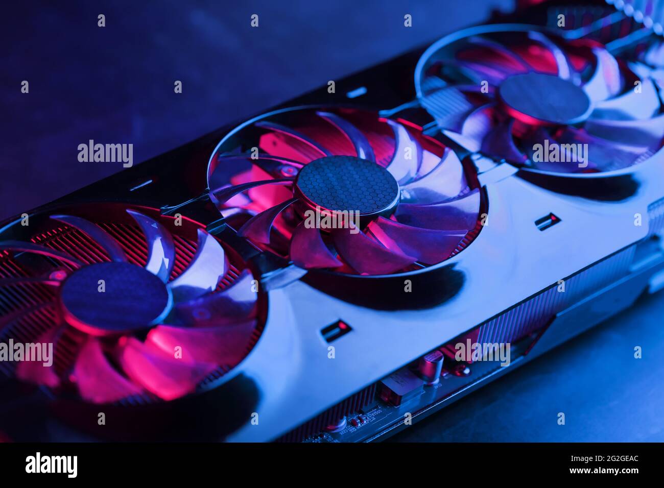 A graphics card with a row of fans with a cyanotic purple backlight in ...