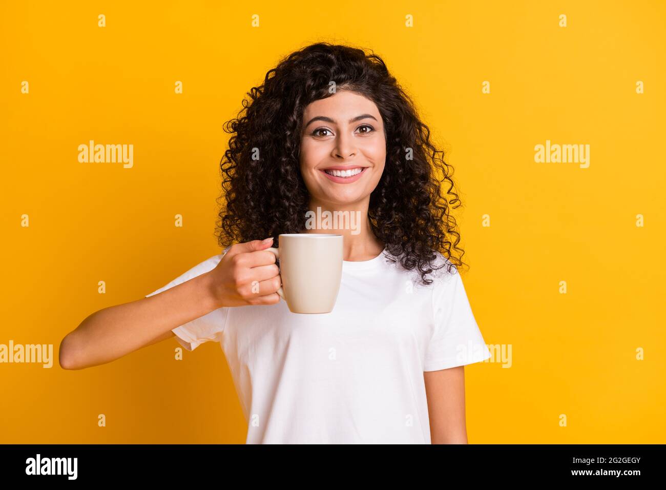 Photo portrait of curly brunette keeping mug with coffee smiling ...