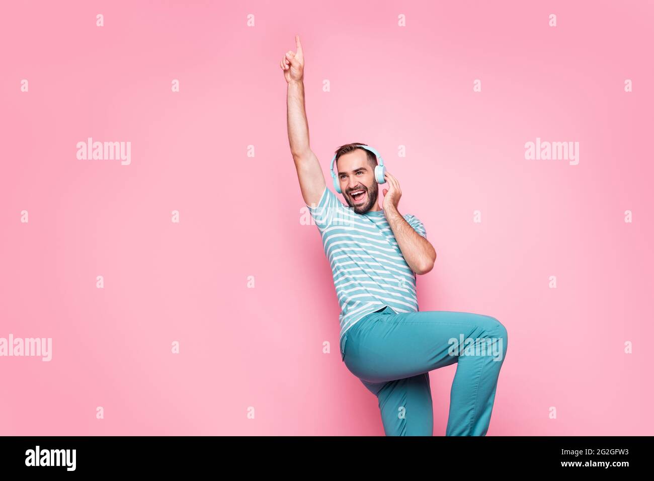 Portrait of attractive cheerful overjoyed guy listening song dancing ...