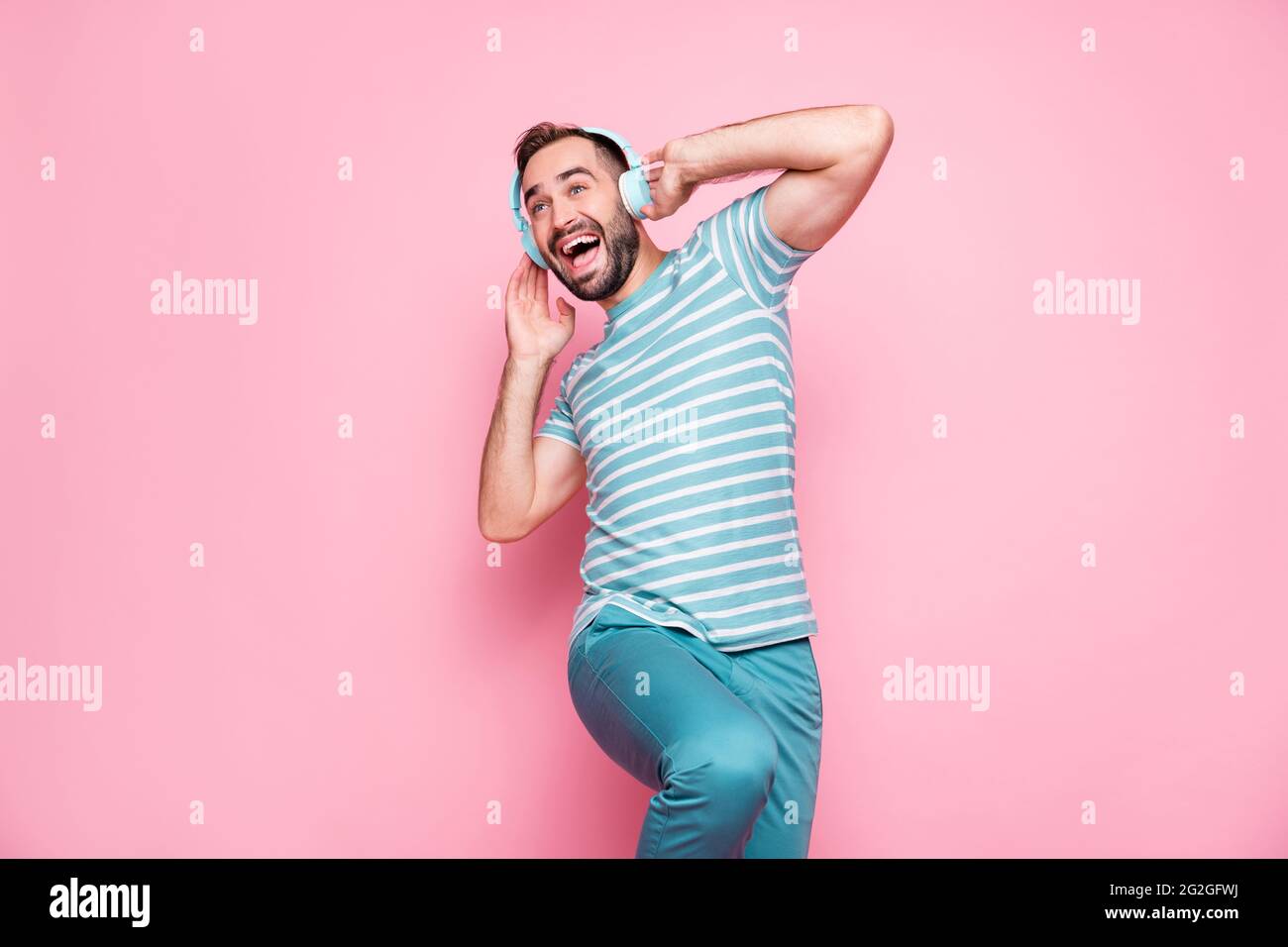 Portrait of attractive cheerful funky glad guy enjoying listening ...