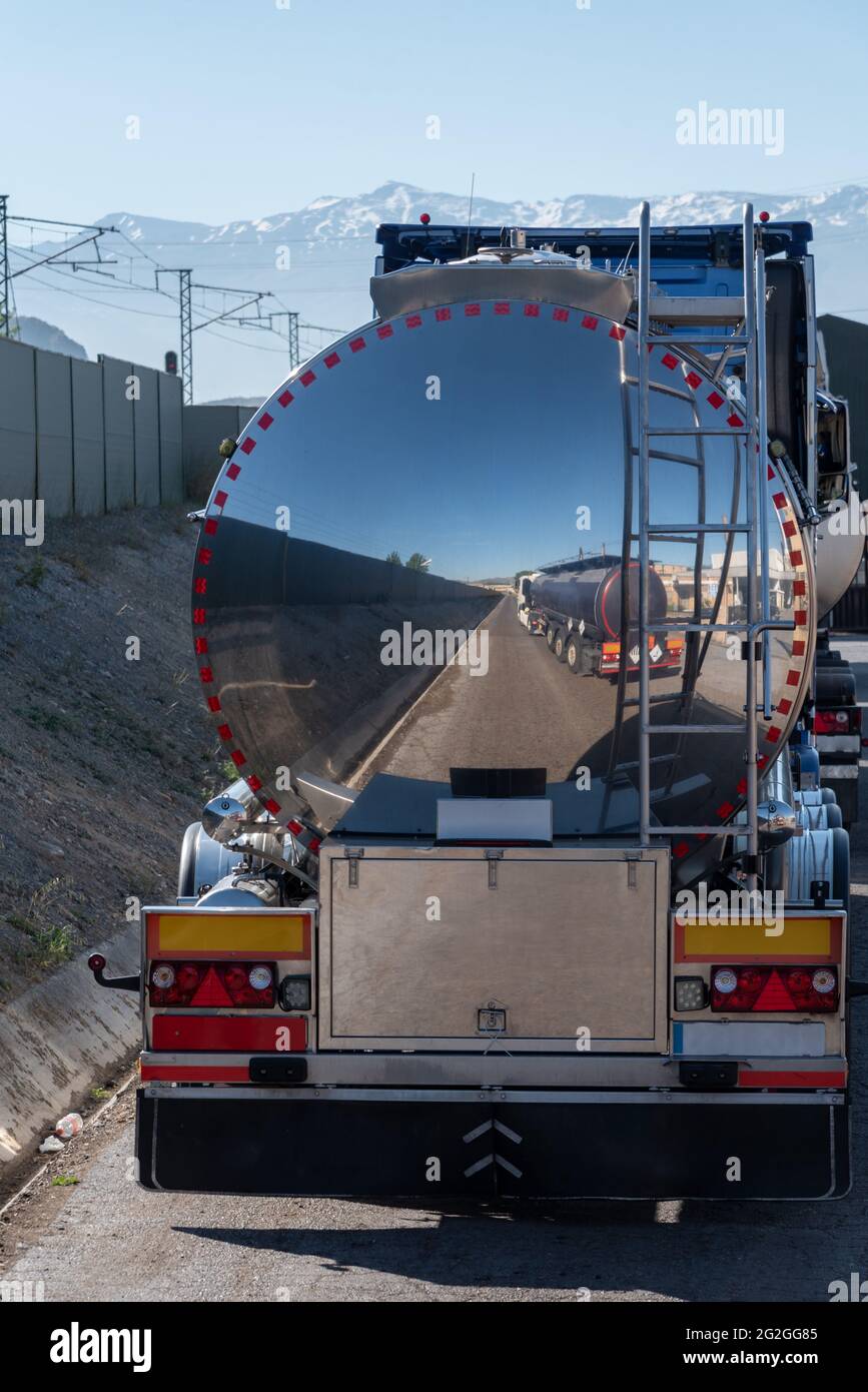 Rear of a tank truck with mirror reflection and where another tank ...