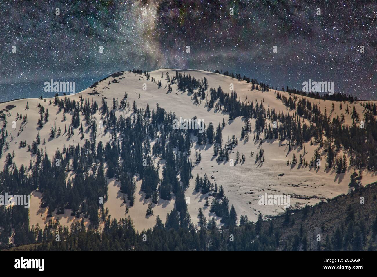 Mesmerizing view of a snow-covered mountain under a scenic starry sky ...