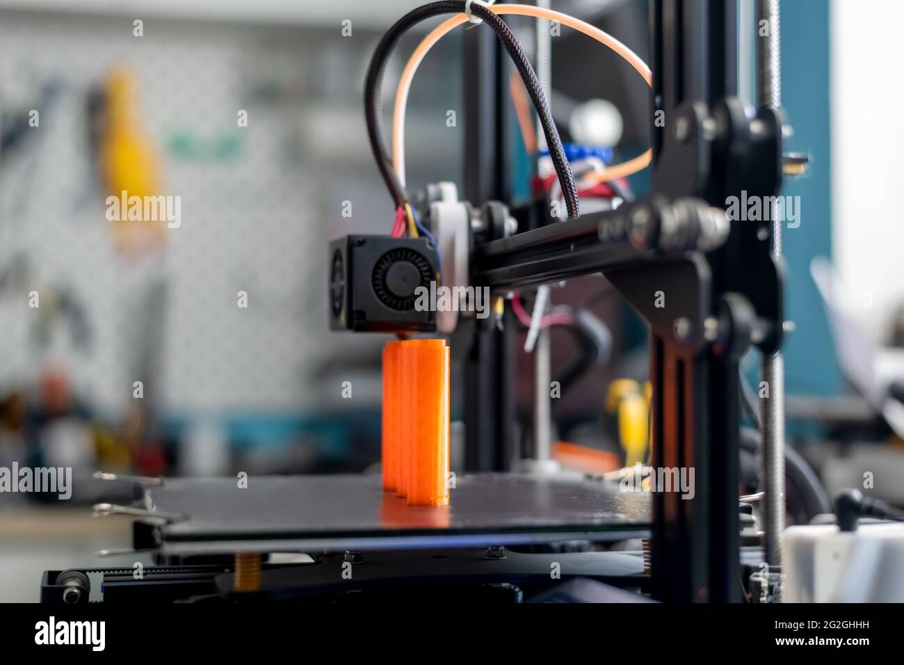 The 3D printer prints orange plastic model. modern technology Stock ...