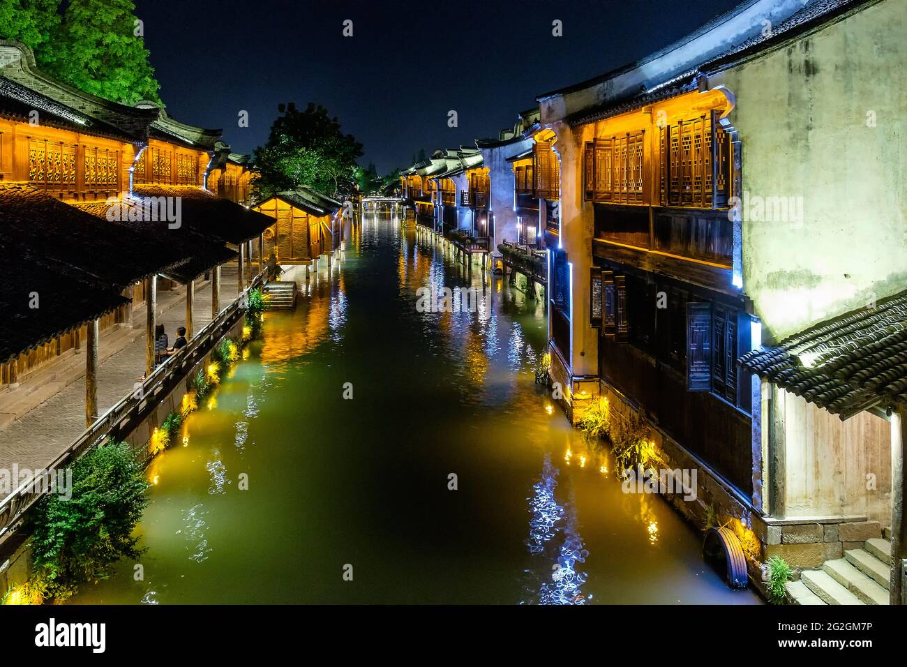 Night time view of illuminated traditional Chinese houses, canal and ...