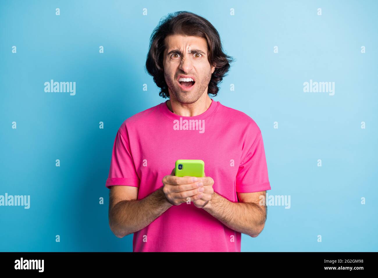 Portrait of outraged guy holding in hands gadget browsing bad news ...