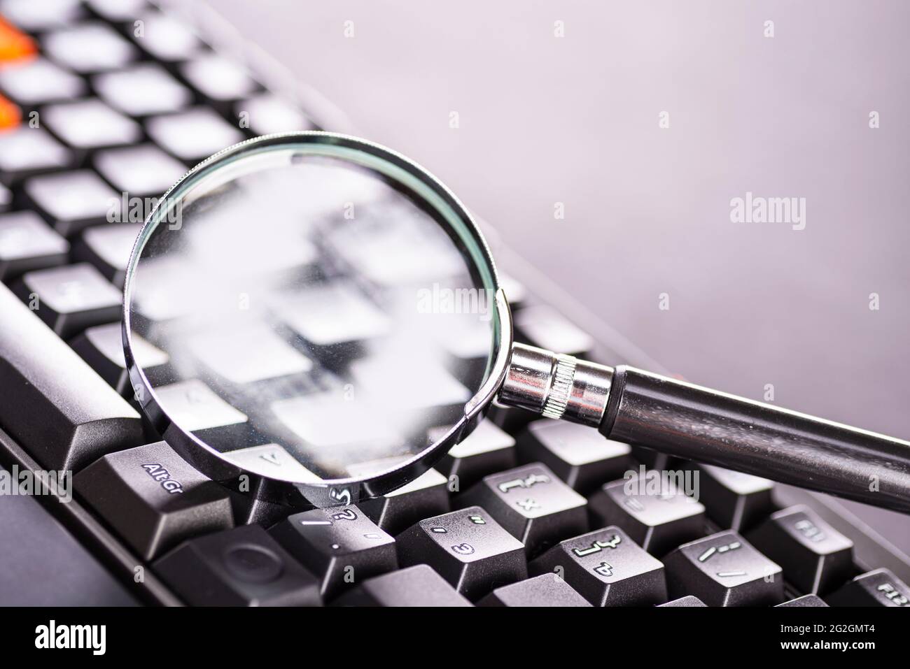 Closeup images of magnifying glass on laptop keyboard Stock Photo - Alamy