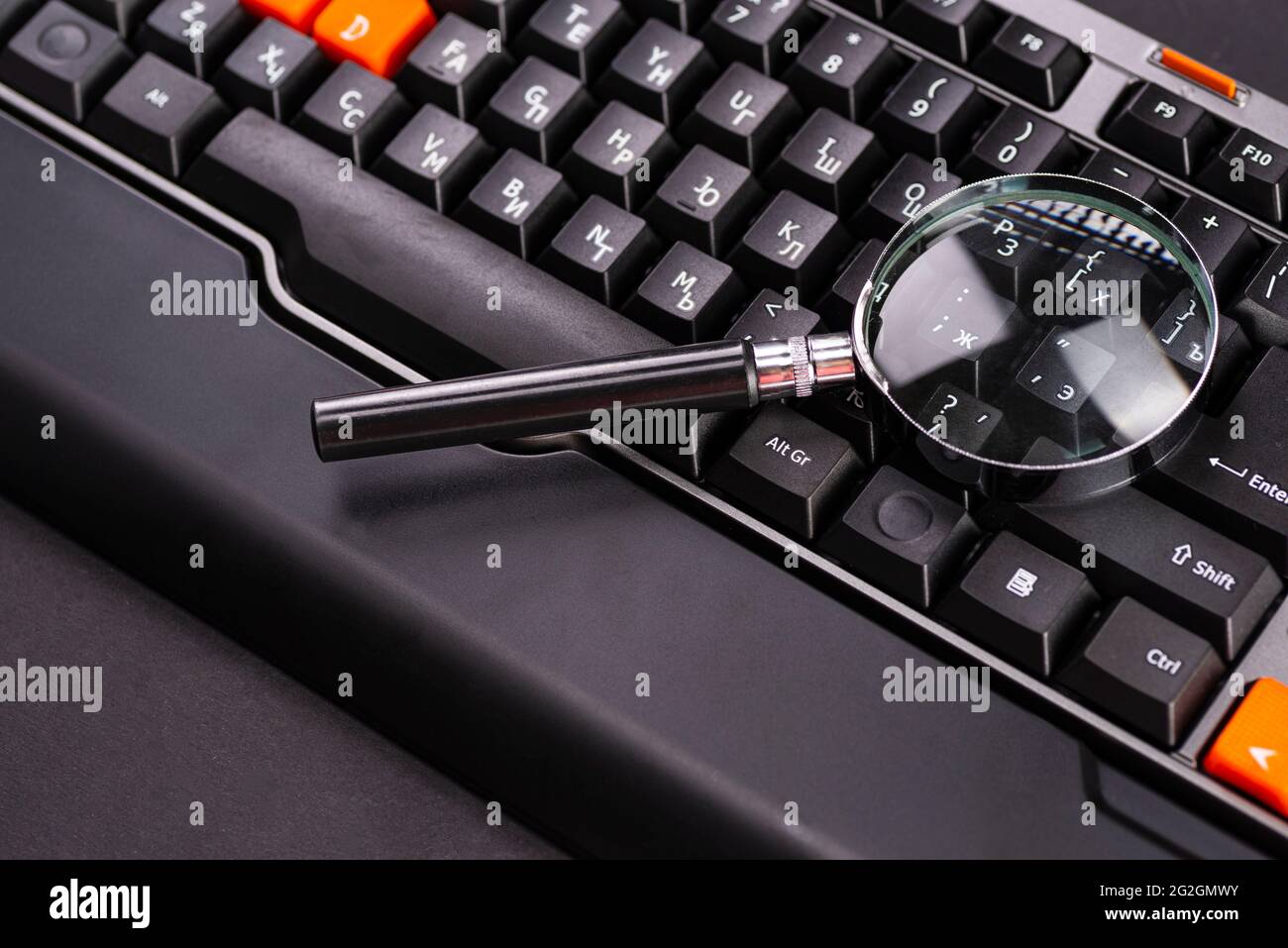 Closeup images of magnifying glass on laptop keyboard Stock Photo - Alamy