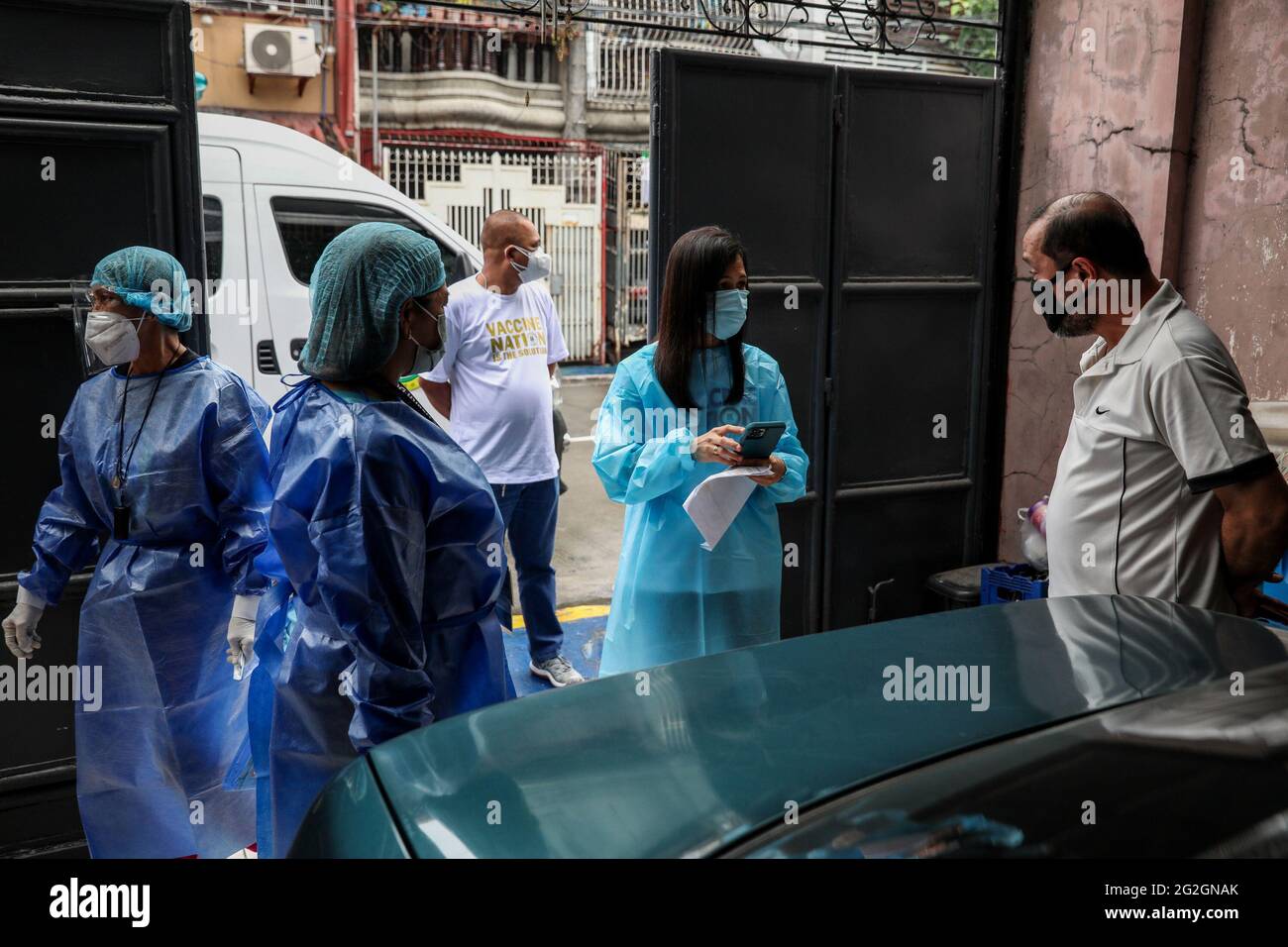 Medical workers prepare to inoculate bedridden patient Regina Vidal ...