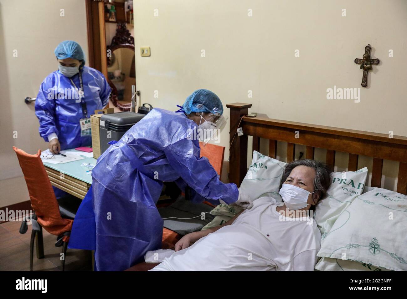 Regina Vidal Agbulos, 64, a bedridden patient, receives a dose of the ...
