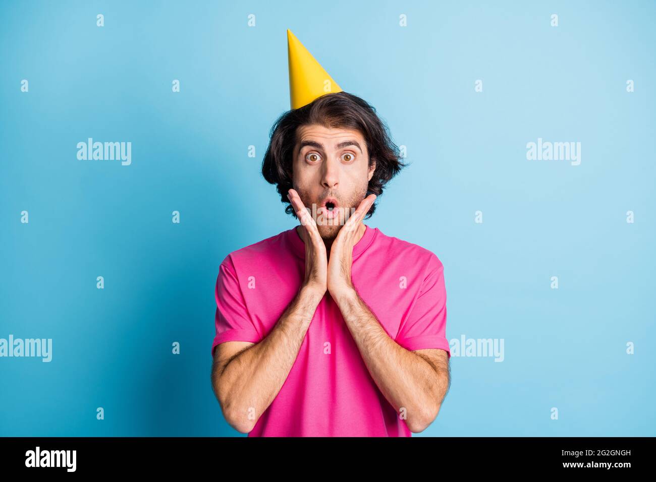 Portrait of amazed emotional guy wearing yellow festal cap pout lips ...