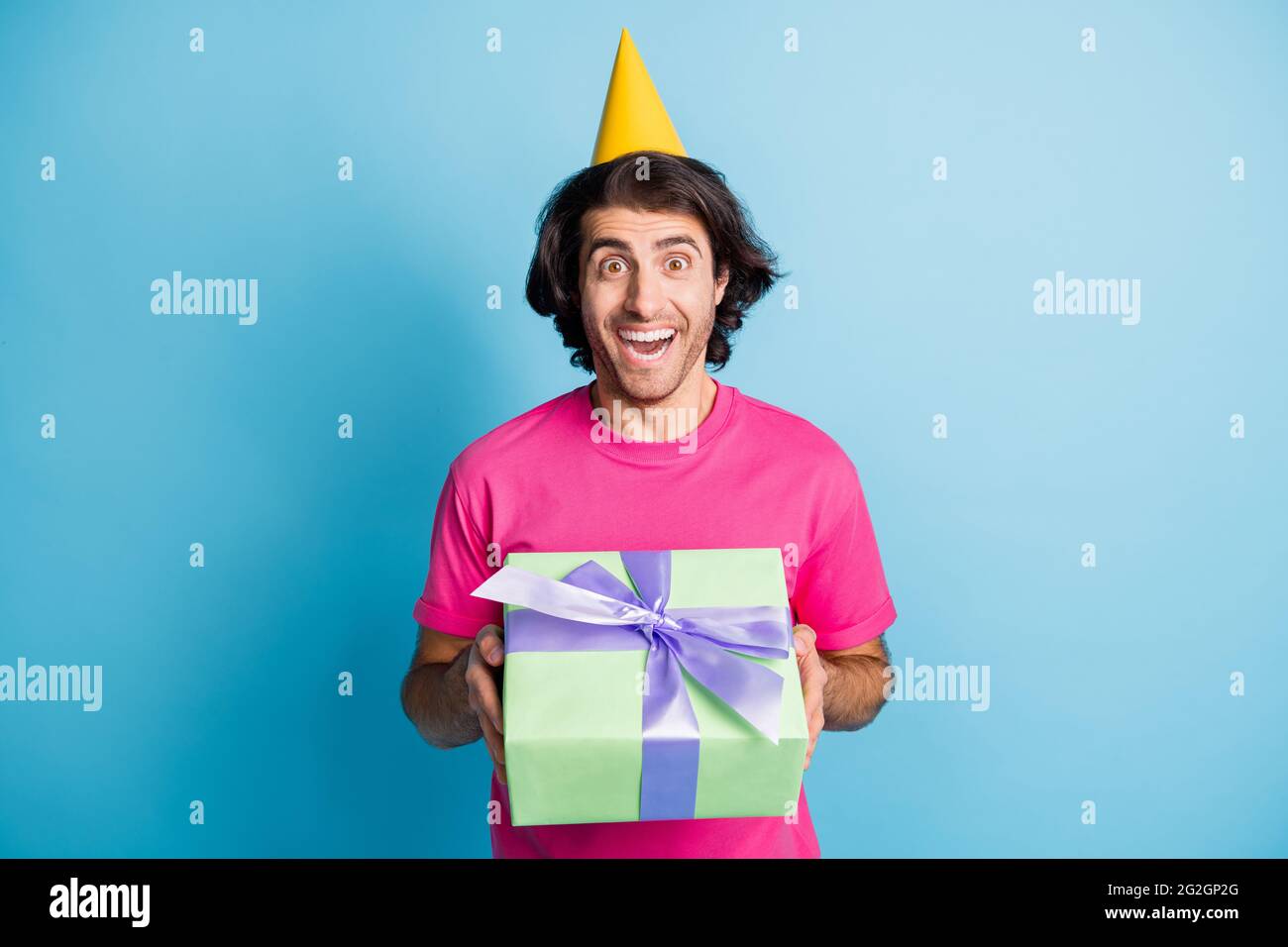 Portrait of nice glad cheerful guy wear festal cap holding in hands ...