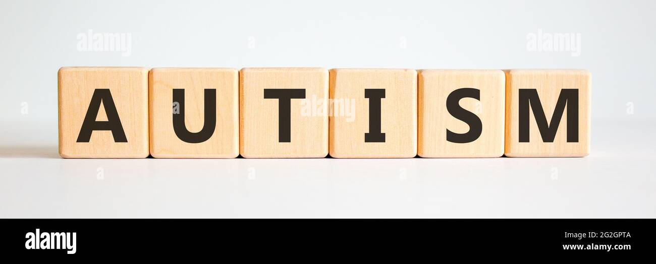 Autism symbol. Wooden cubes with the word 'autism'. Beautiful white ...