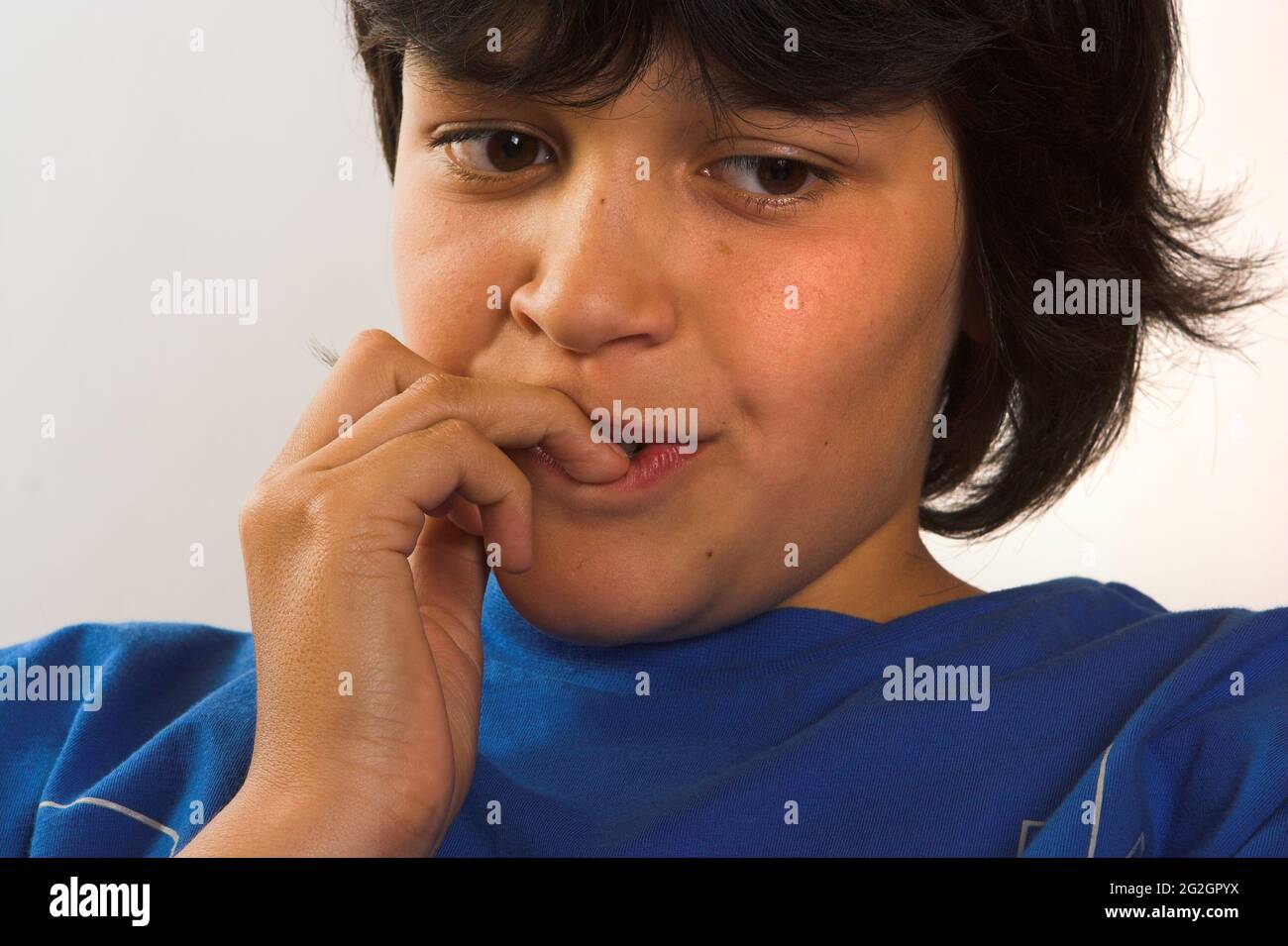 Boy biting his finger nails, dreaming Stock Photo - Alamy