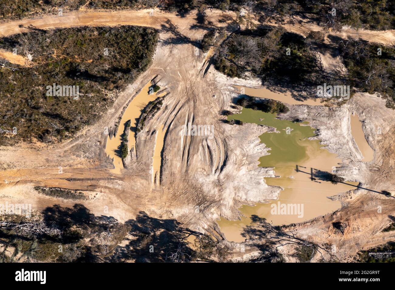 Drone aerial photograph of flood water on a dirt road in a forest in ...