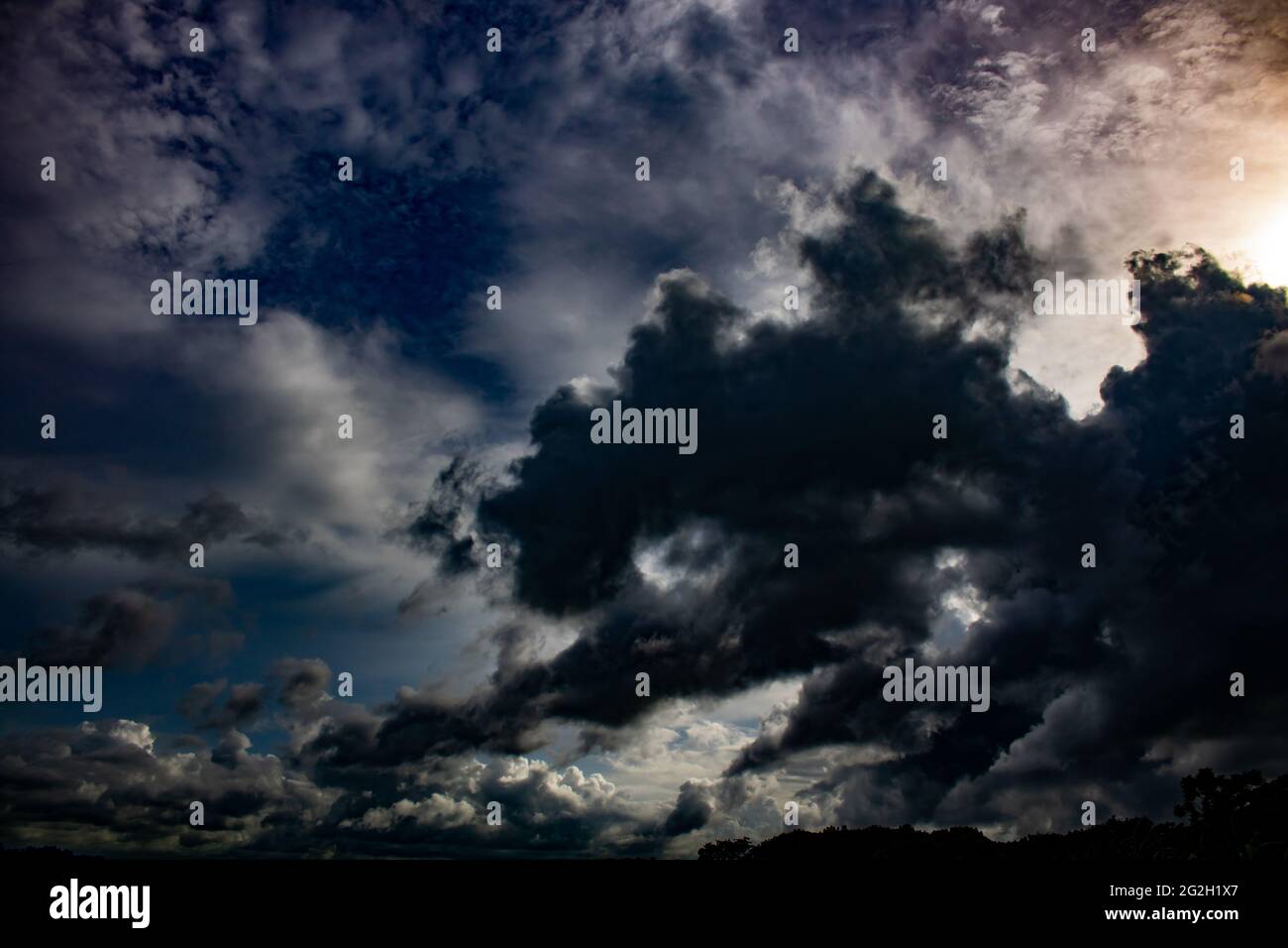 Thick black clouds in the sunny sky Stock Photo - Alamy