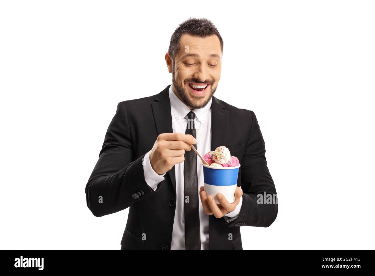 Young businessman eating ice cream from a paper cup isolated on white ...