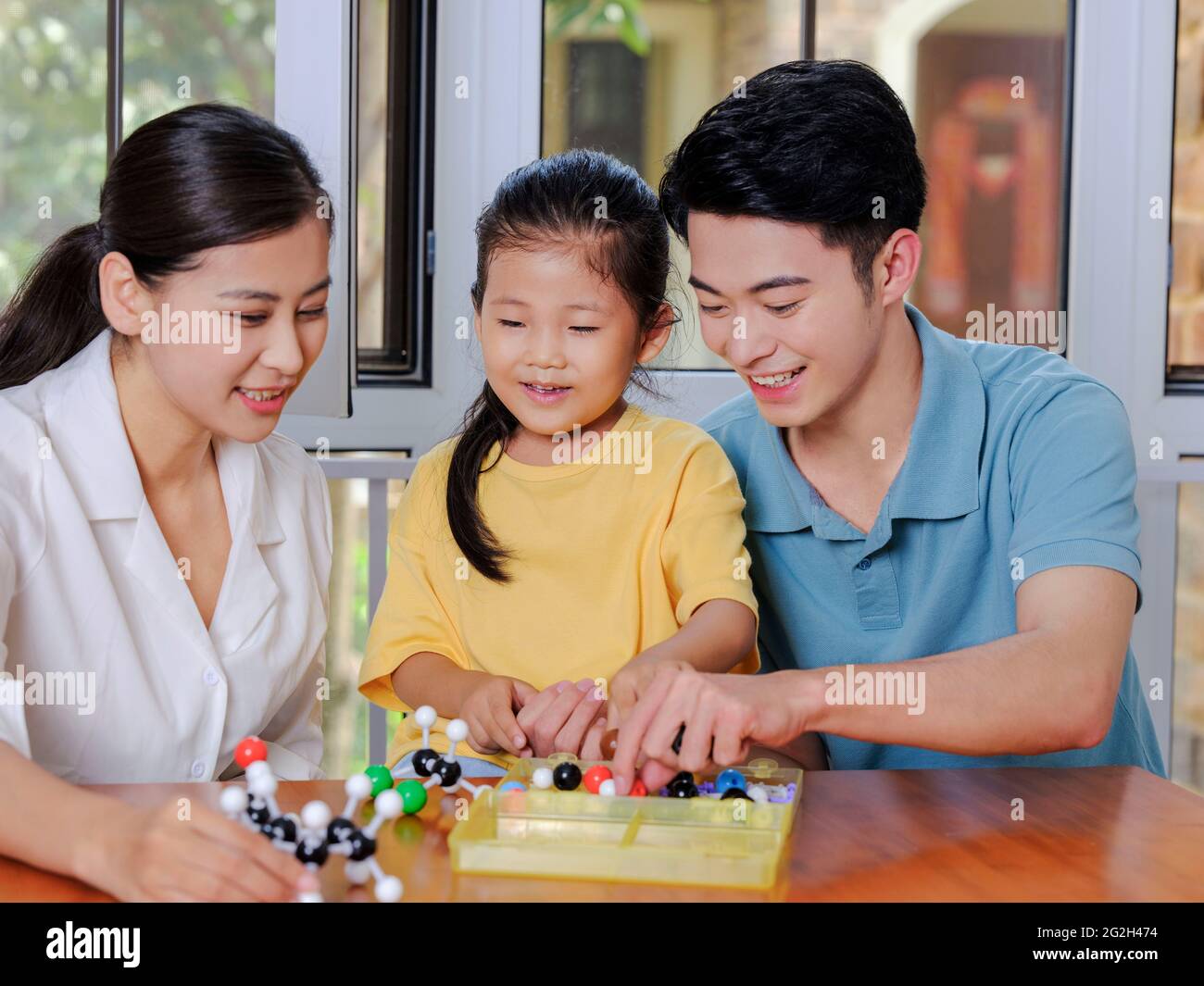 Happy family of three doing molecular structure model together high ...