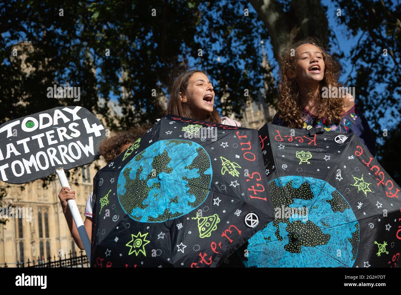 Two girls with umbrellas protesting against climate change outside the ...