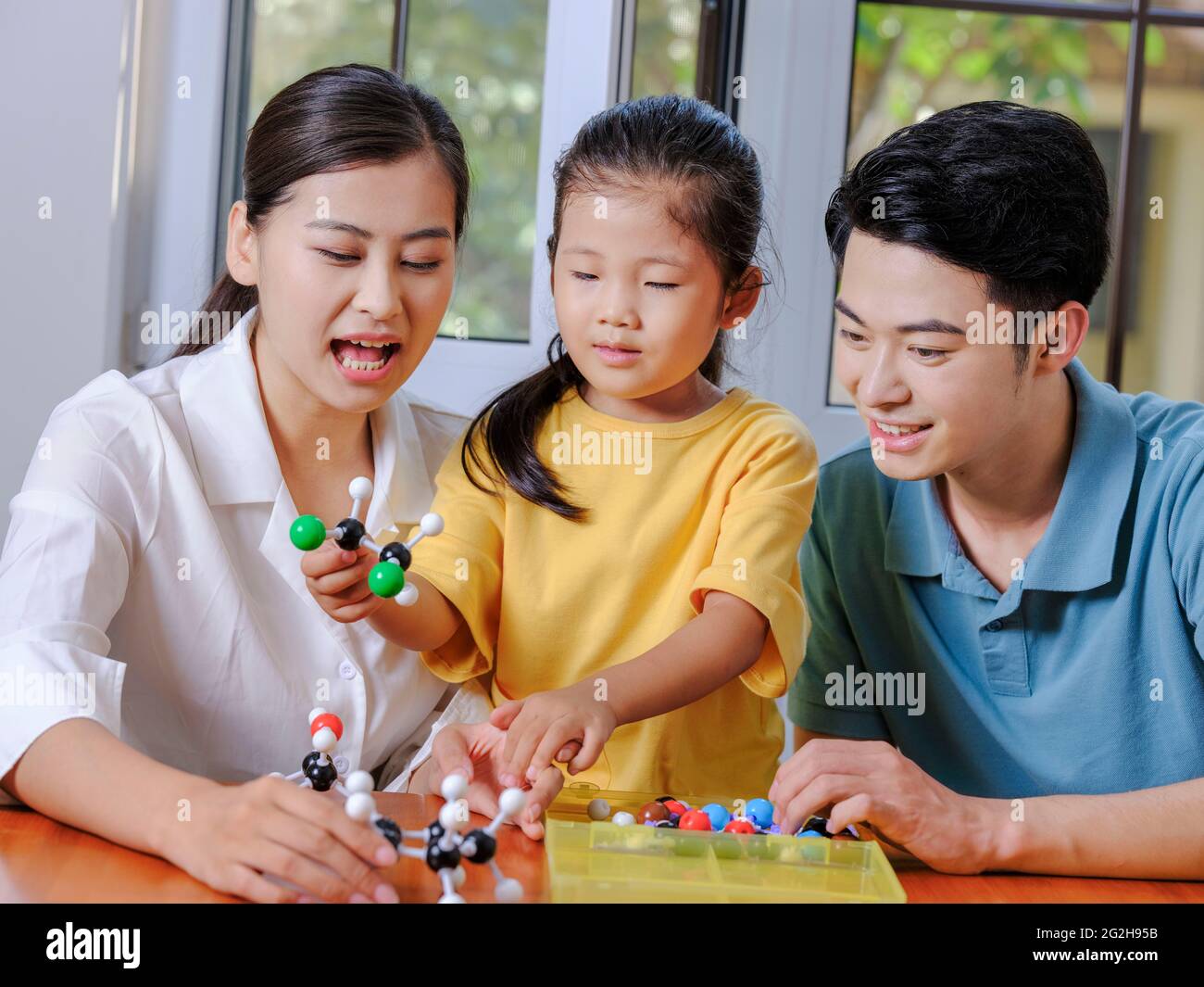Happy family of three doing molecular structure model together high ...