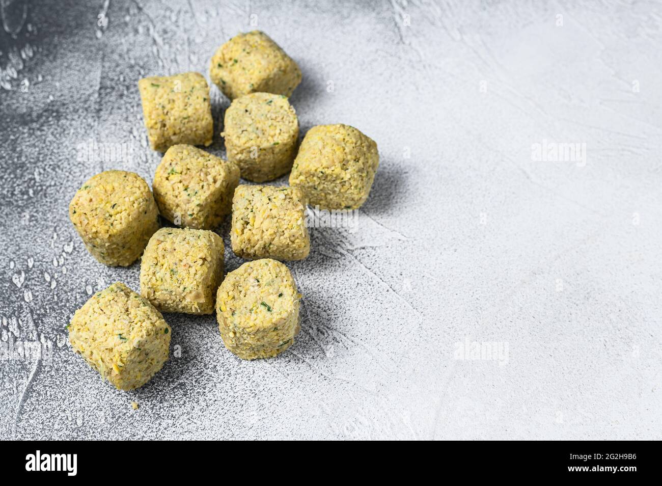 Raw falafel balls on a kitchen table. White background. Top view. Copy ...