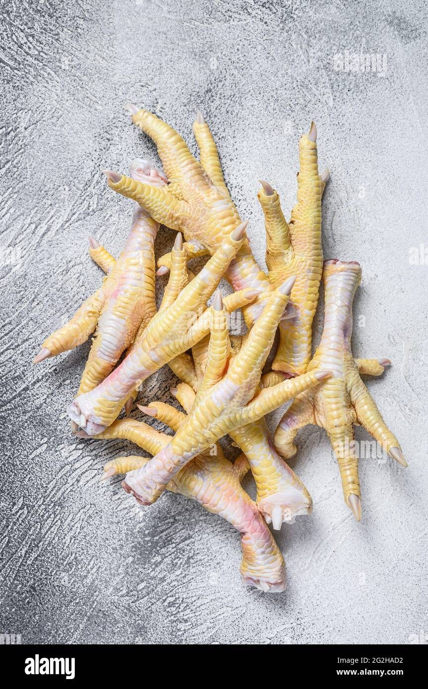 Raw Chicken feets on kitchen table. White background. Top view Stock ...