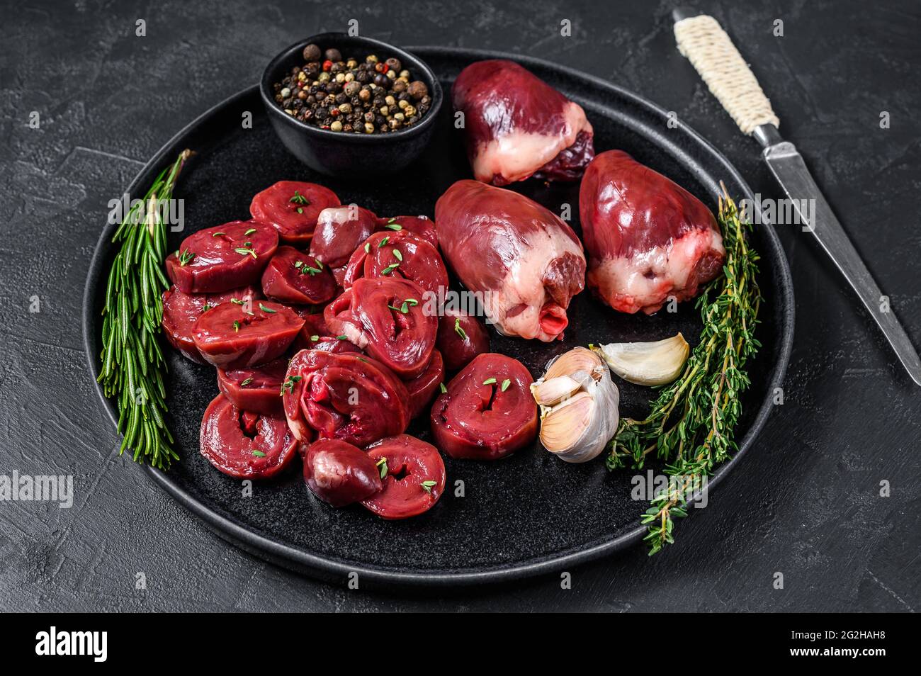 Sliced Raw turkey hearts ready for cooking. Black background. Top view ...