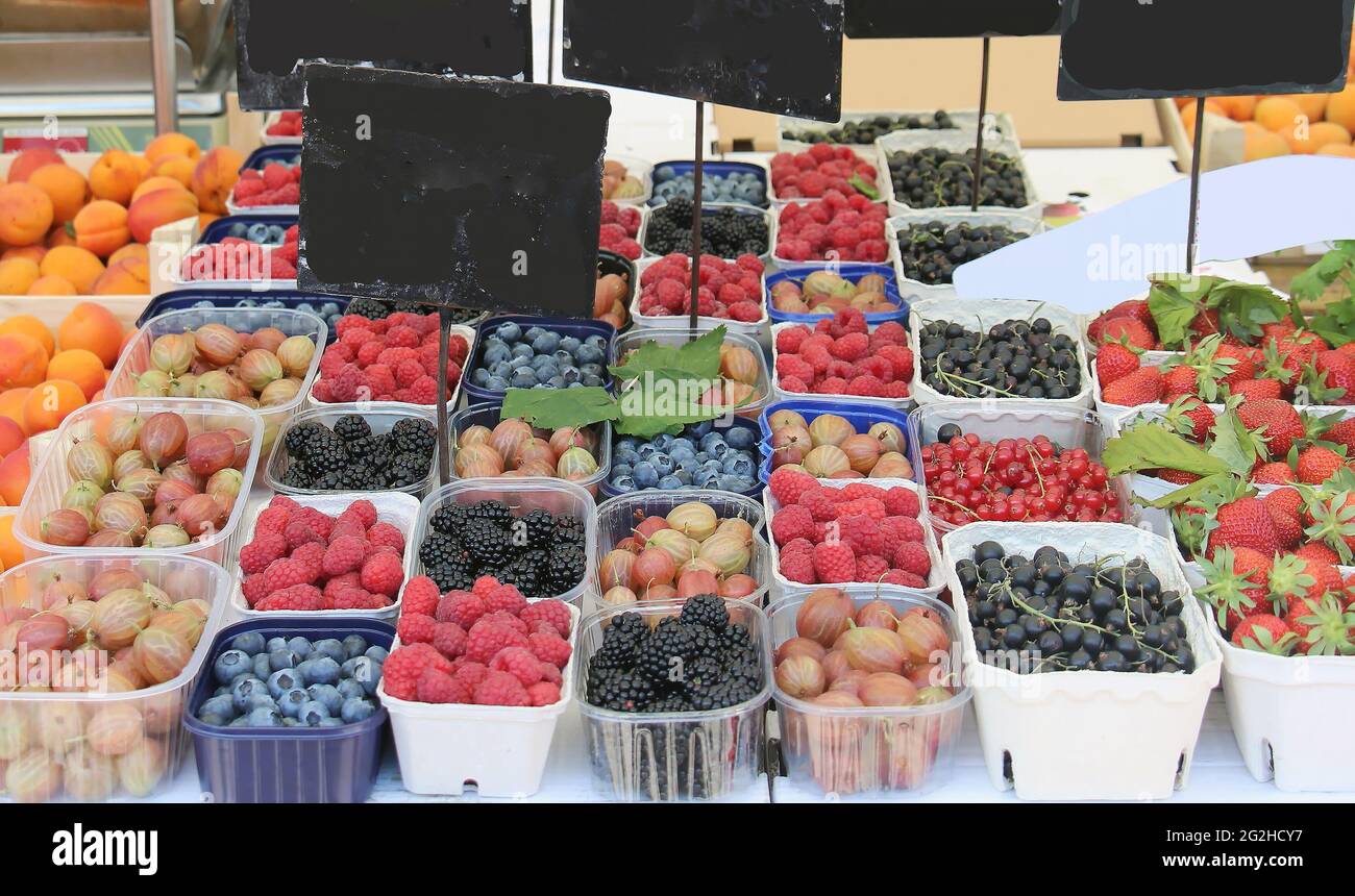 Fresh raw organic fruits in containers sold on outdoor market stall ...