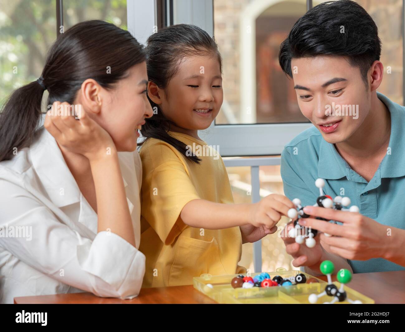 Happy family of three doing molecular structure model together high ...