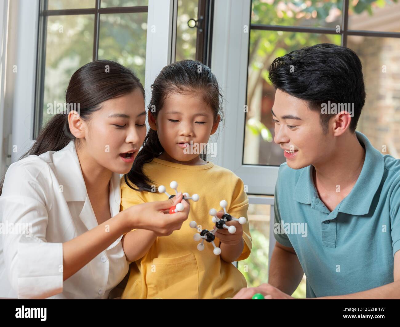 Happy family of three doing molecular structure model together high ...