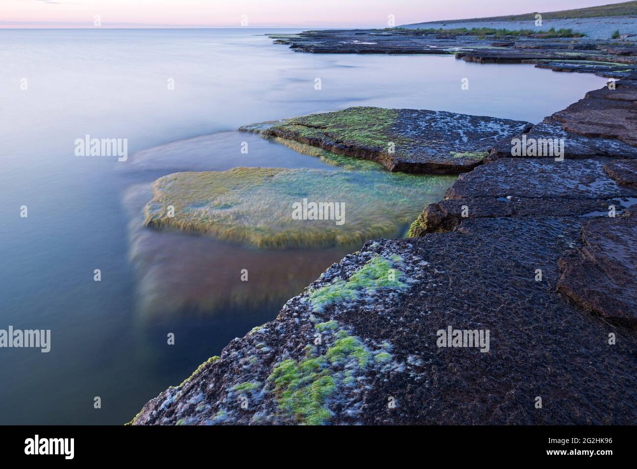 Evening mood on the coast at Byxelkrok, water laps the stone slabs in ...