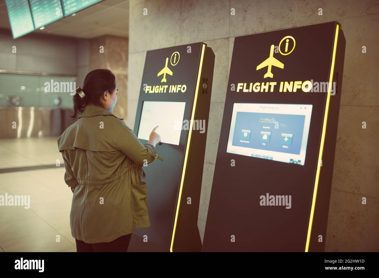 Young woman checking time at the flight info kiosk in the airport Stock ...