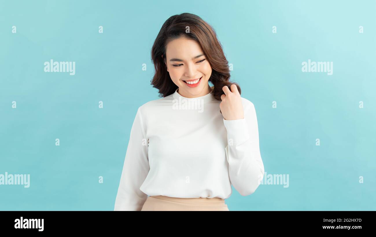 Portrait of tender smiling woman gently touching face and blushing ...