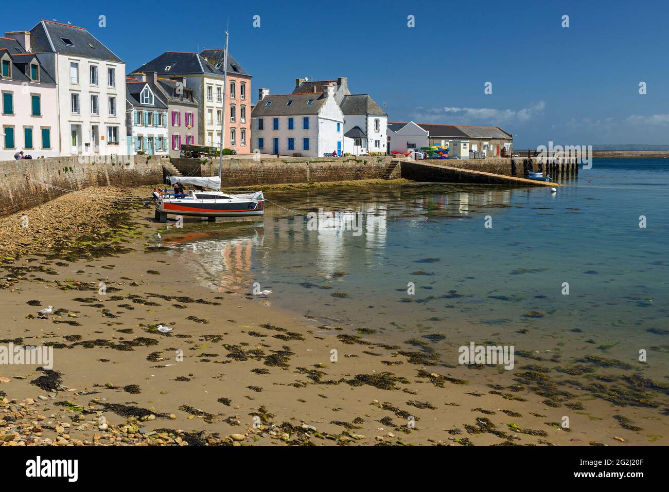 Île de Sein, colorful houses and sailing boat in the harbor, France ...