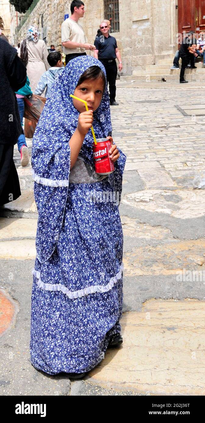 A young Palestinian girl drinking Crystal Cola in the Muslim quarter of ...