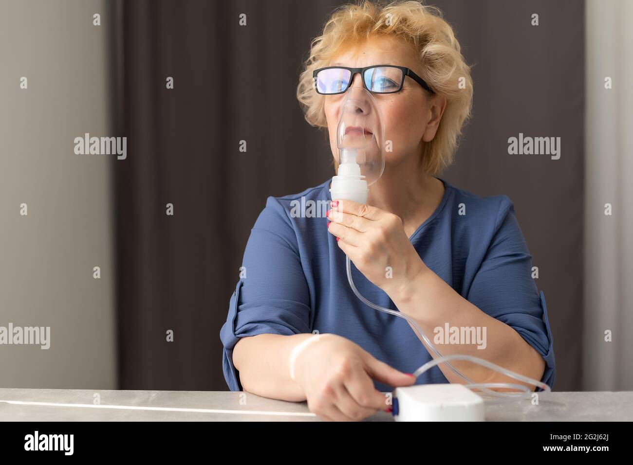 Sick elderly woman making inhalation, medicine is the best medicine ...
